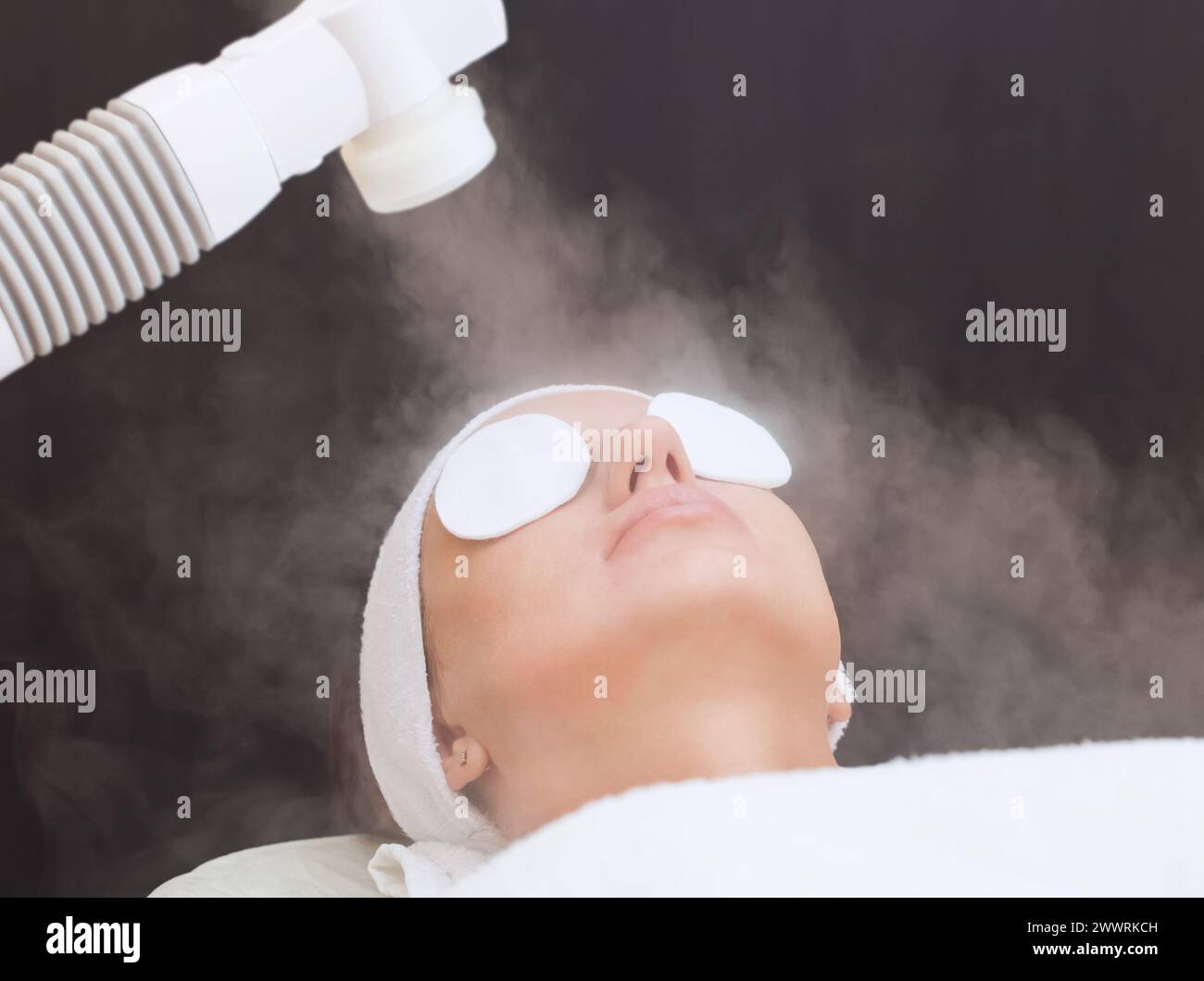 The procedure of steaming the skin of the face of a young woman before ...
