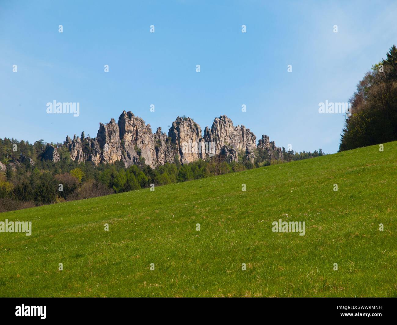 Sharp sand stone rock formation with green meadow and blue sky Stock ...