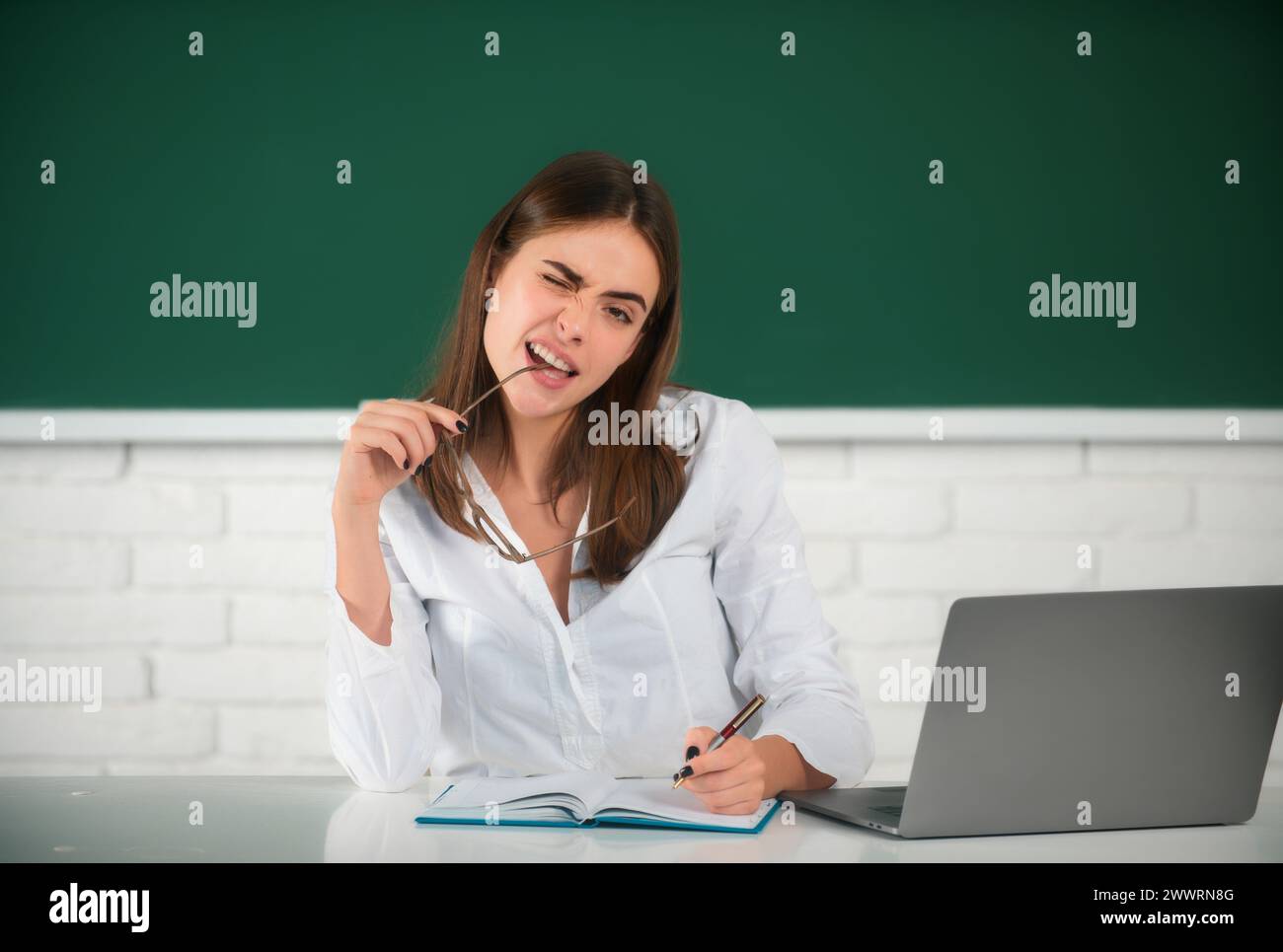 Portrait of a funny female student studying in school classroom. Female freelancer or a student ...