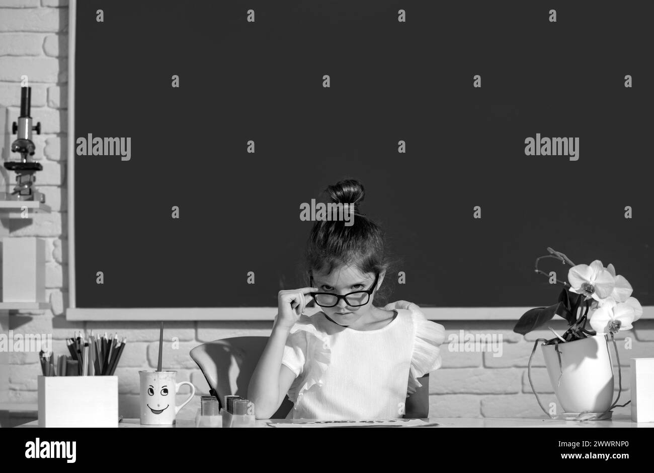 Child girl draws in classroom sitting at a table, having fun on school ...