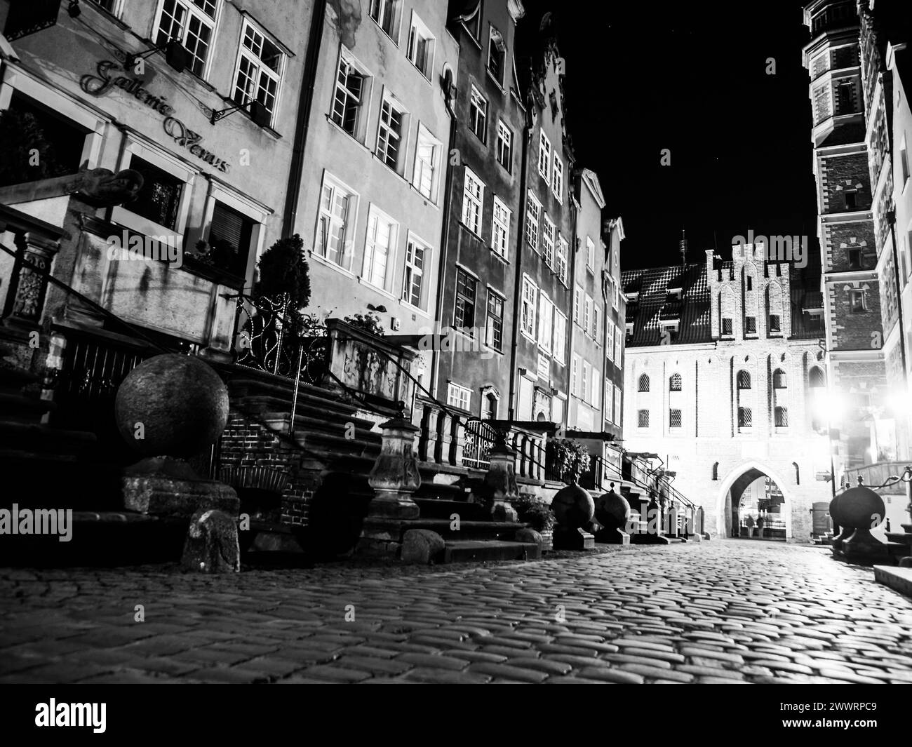 Mariacka street by night in Old Town of Gdansk, Poland. Black and white ...