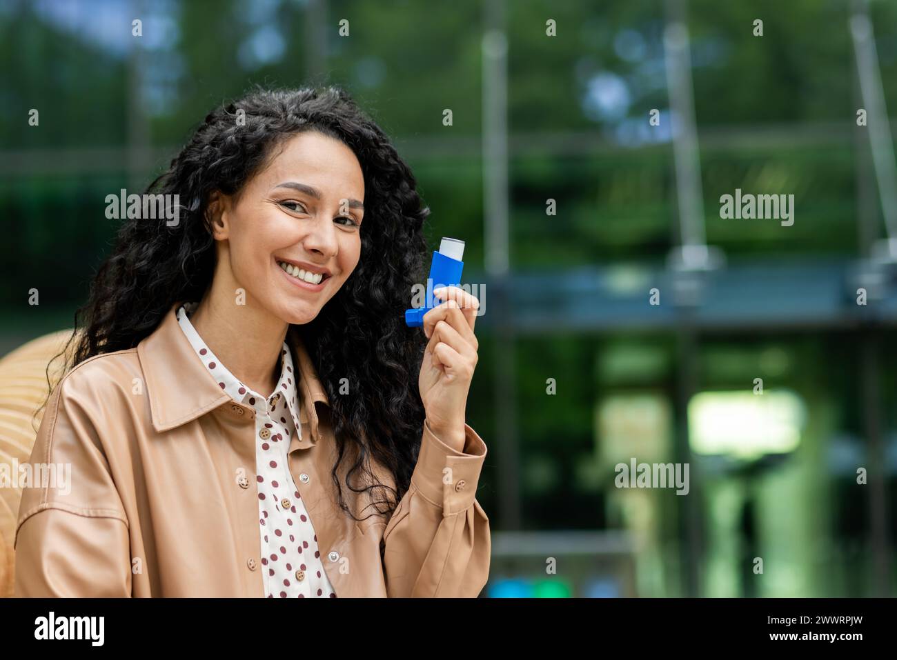 Smiling caucasian female holding blue inhaler close to face on ...