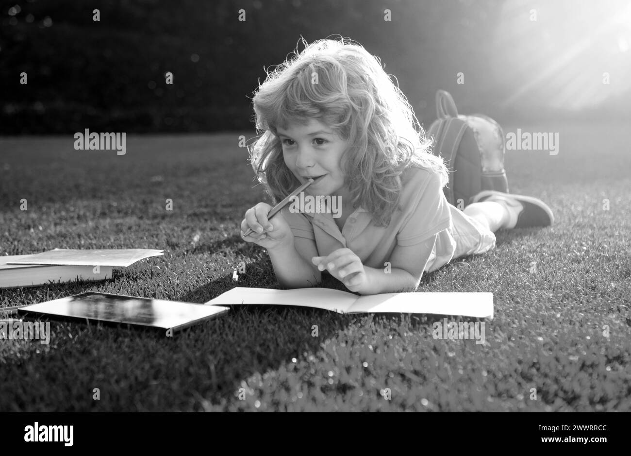 Portrait of happy child boy with book in park. Kids early education ...