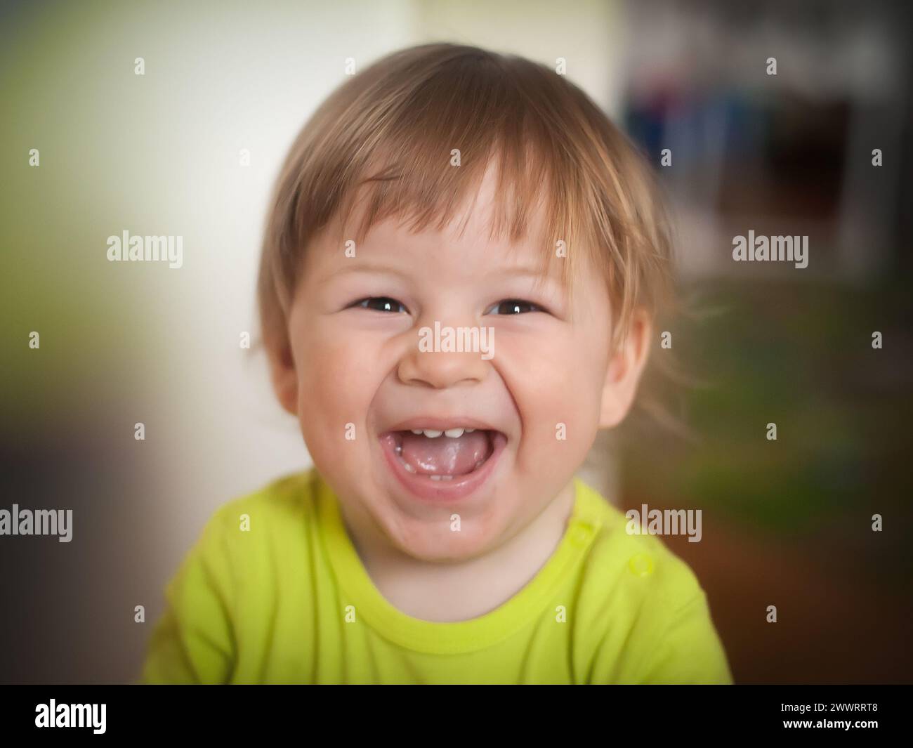 Beaming smile of happy cute toddler in a cozy home setting at playtime ...