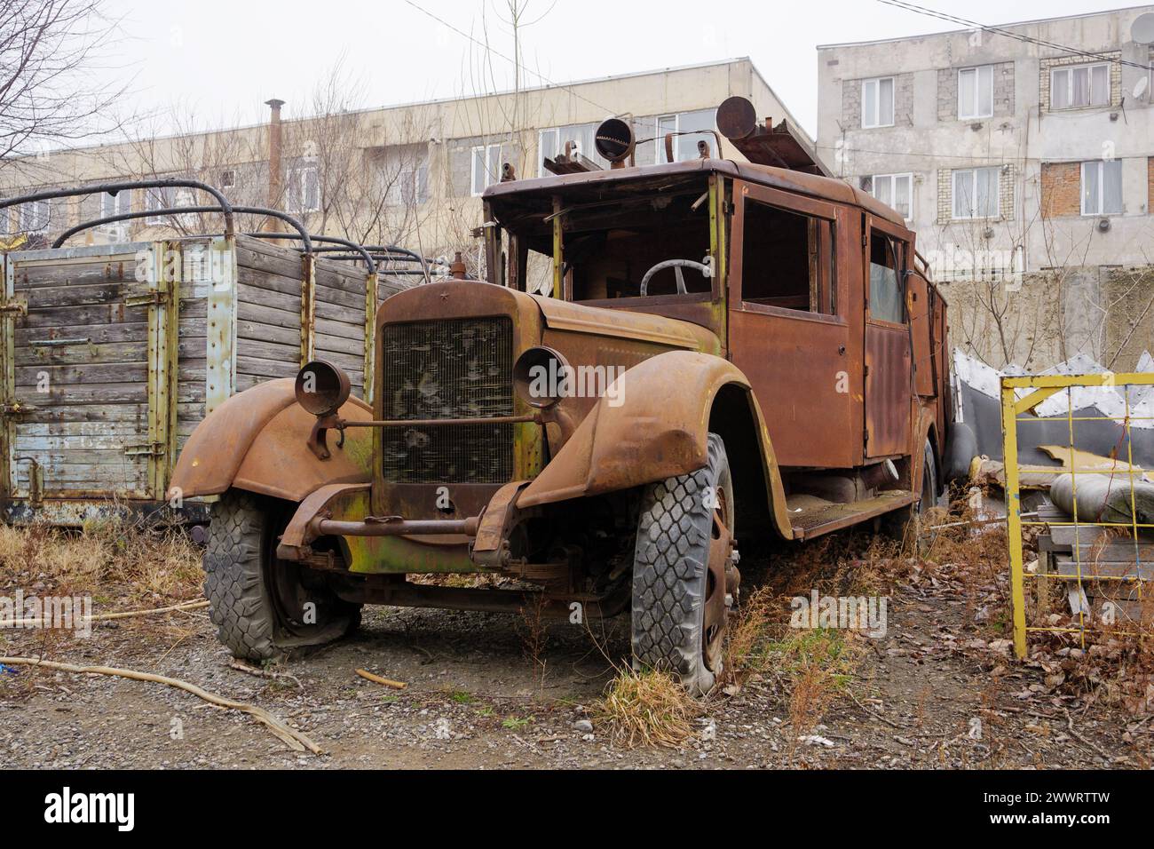 A rusty vintage Soviet truck stands abandoned by industrial buildings ...