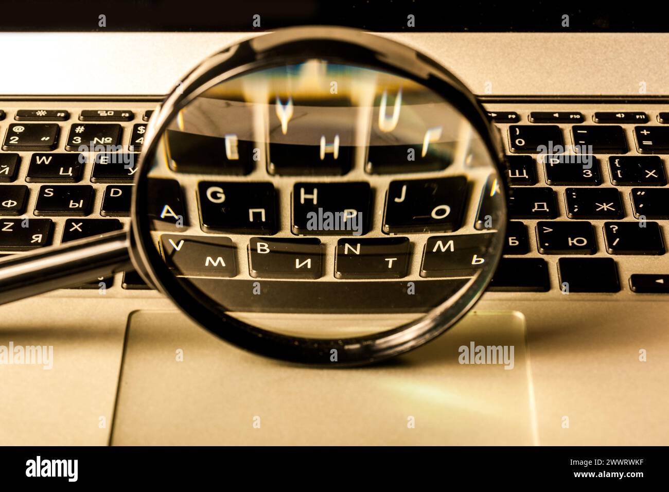 Closeup images of magnifying glass on laptop keyboard Stock Photo - Alamy