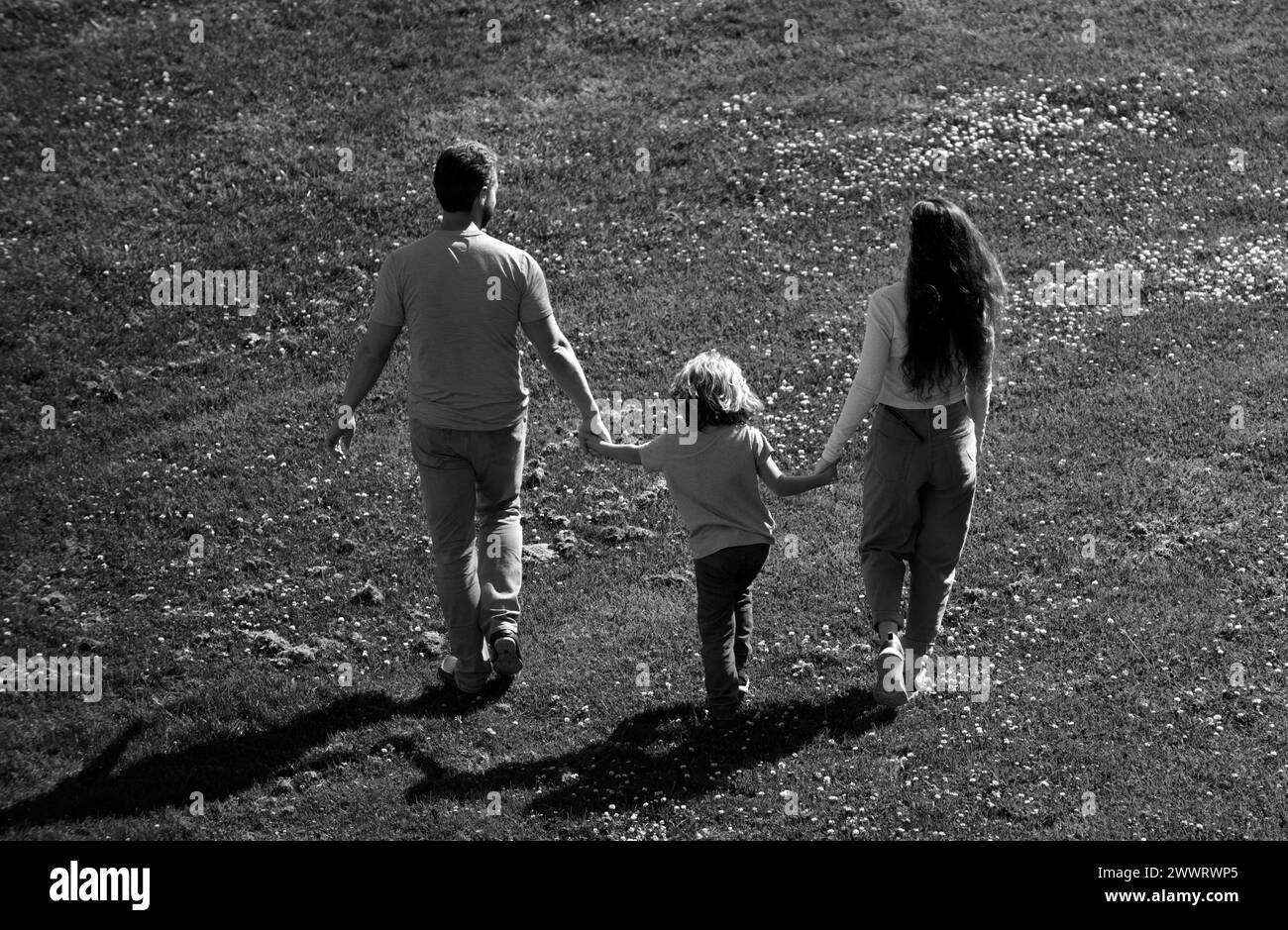 Back view of family spending time together outside in green nature ...
