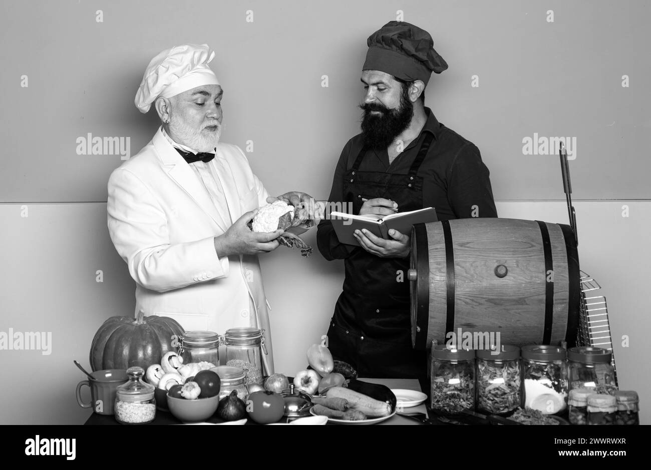 Chef garnishing food in the kitchen. Chef leaning on the counter with a ...