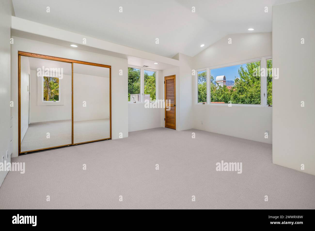 An unoccupied white room with multiple doors on the wall Stock Photo ...