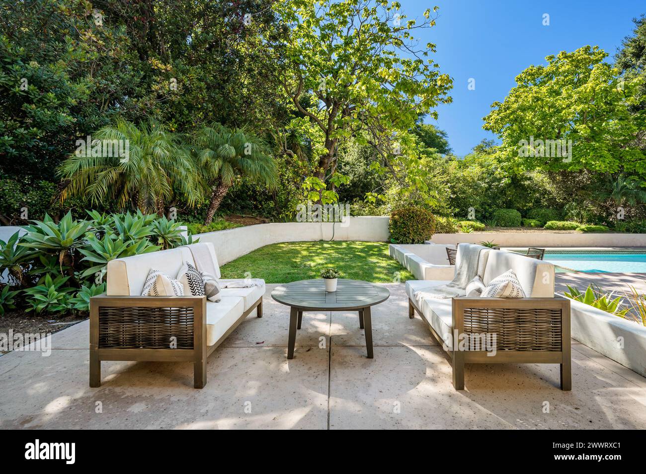 Patio with firepit and poolside lawn area Stock Photo - Alamy