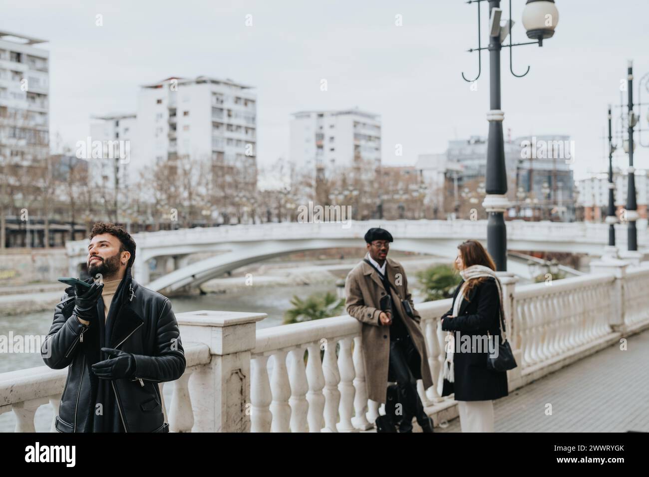 A young, bearded businessman wearing a leather jacket is having a phone ...
