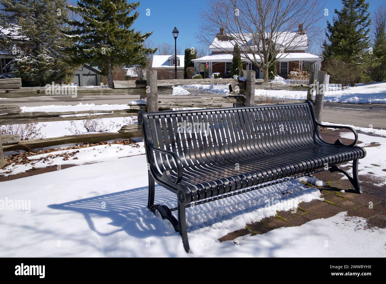 Winter landscape. Empty park bench in the park of a small Canadian ...