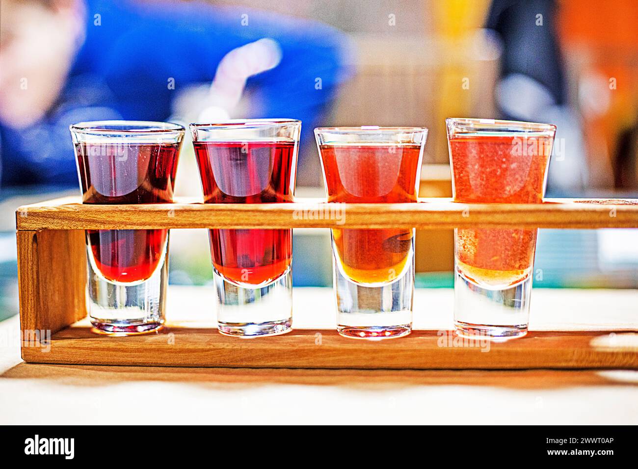 tasting of colorful fruit and berry liqueurs on a wooden stand on a ...