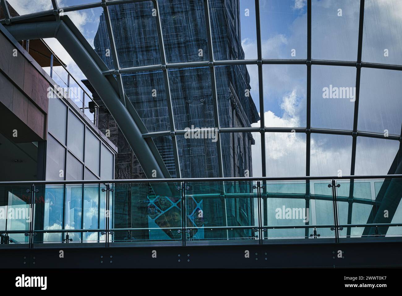 Modern glass building facade with reflections of clouds, showcasing ...