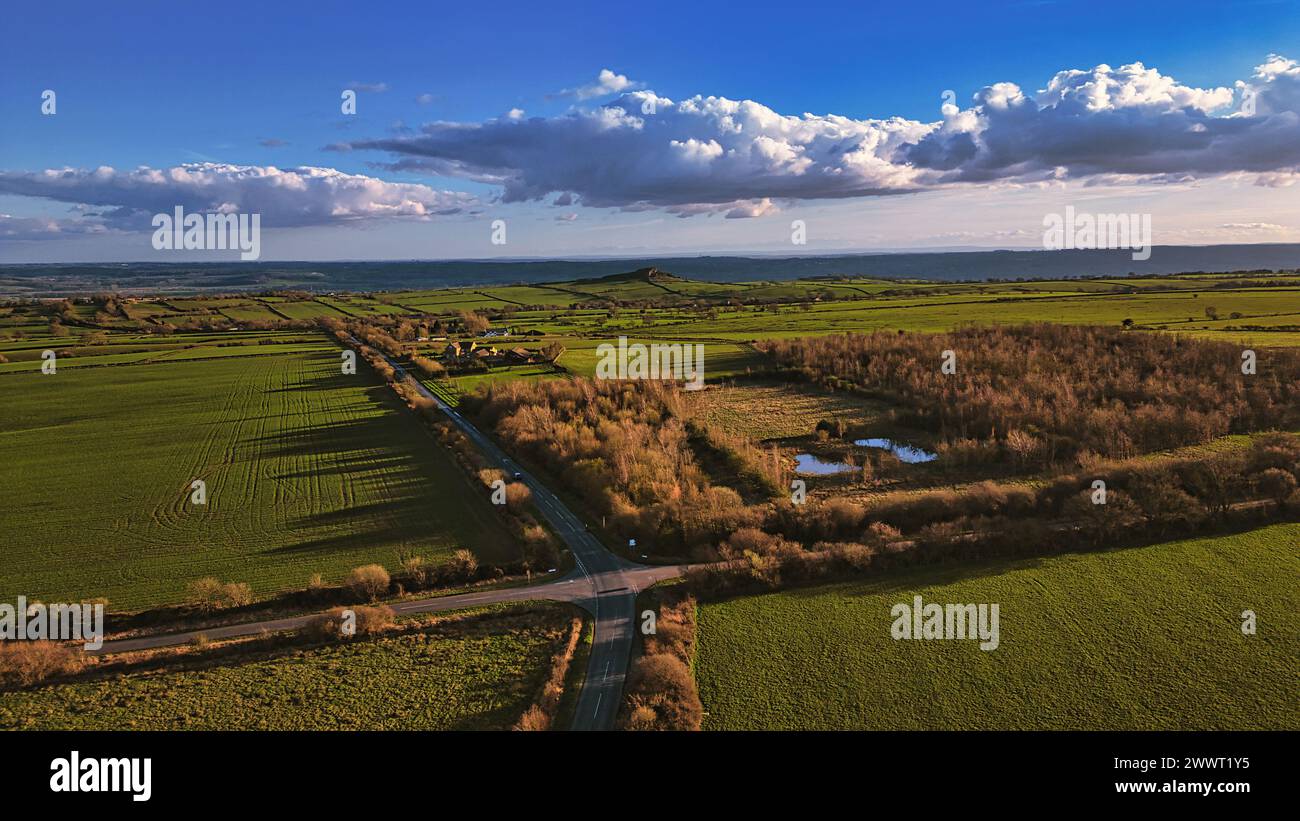 Aerial view of lush countryside with green fields, trees, and a small ...