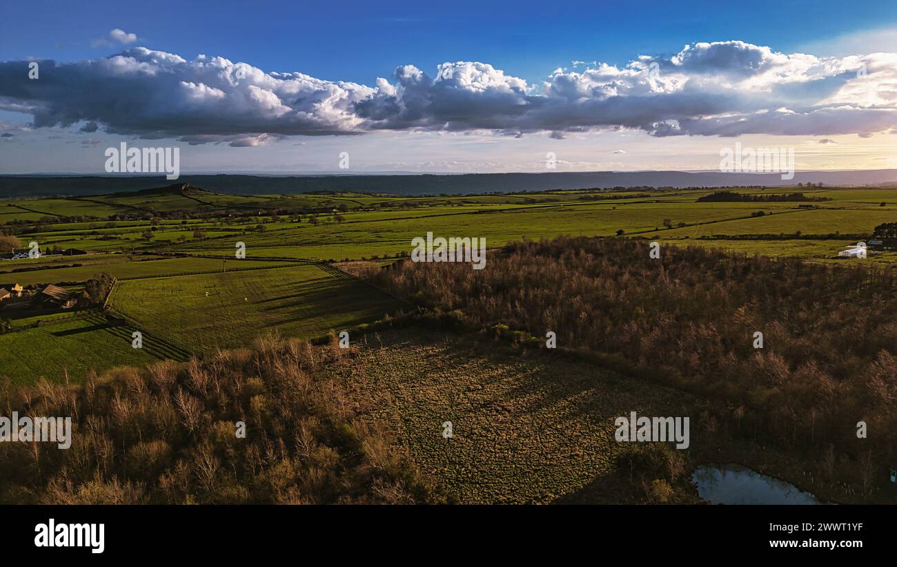 Aerial view of a lush countryside with fields and trees under a ...