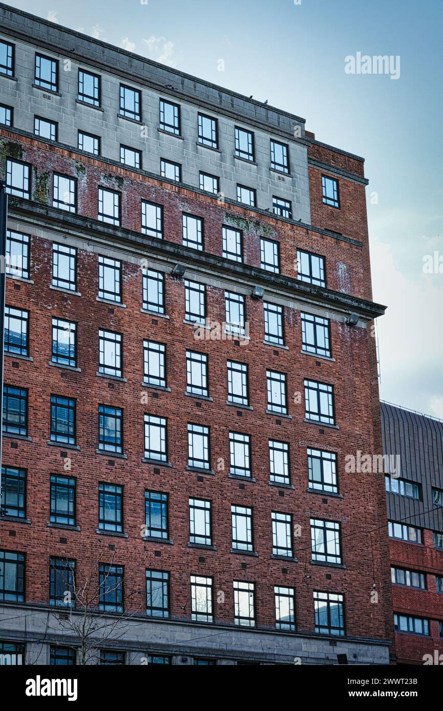 Facade of a modern red brick building against a clear blue sky ...