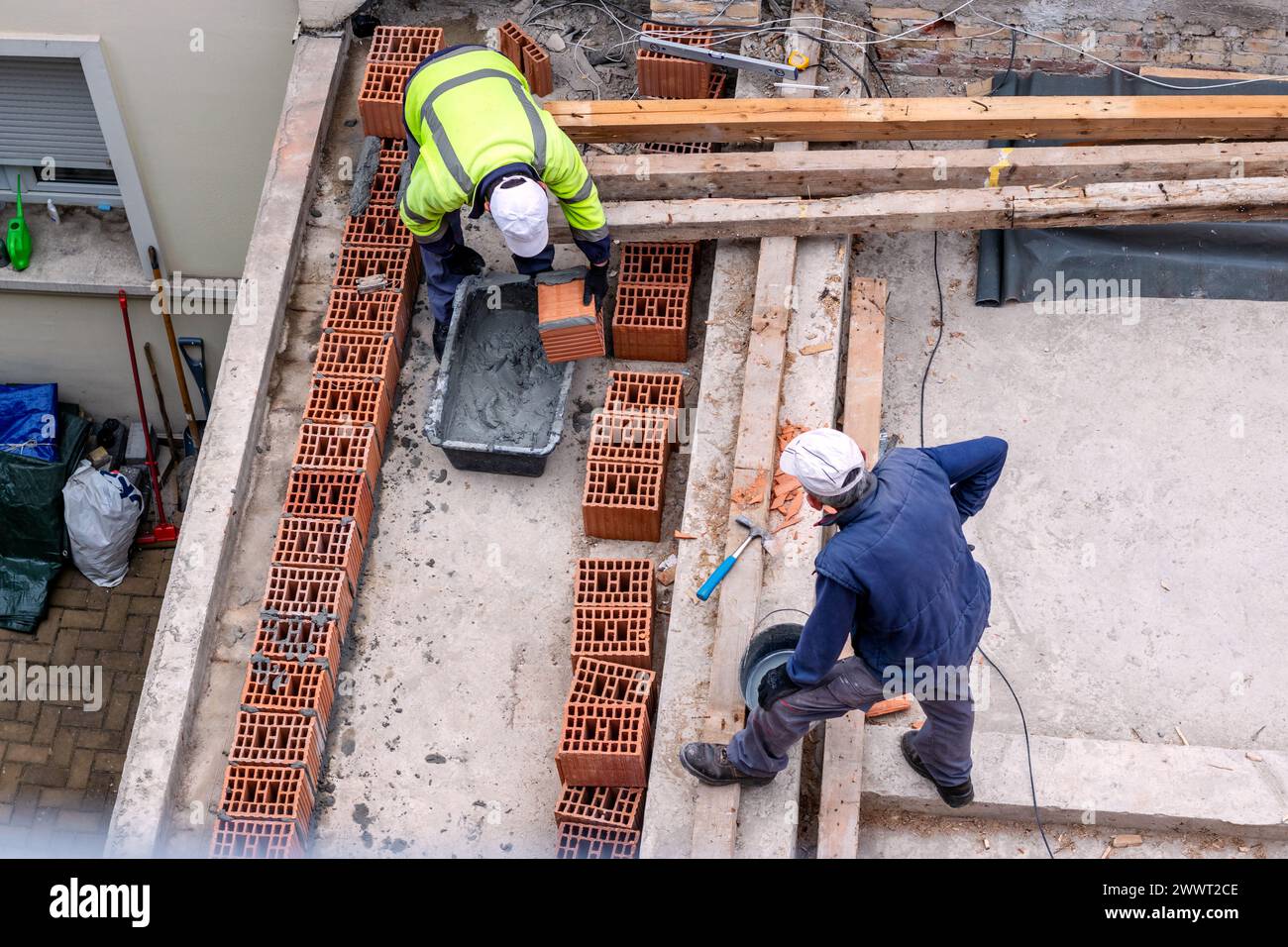 Construction worker using pan knife for building brick walls with ...