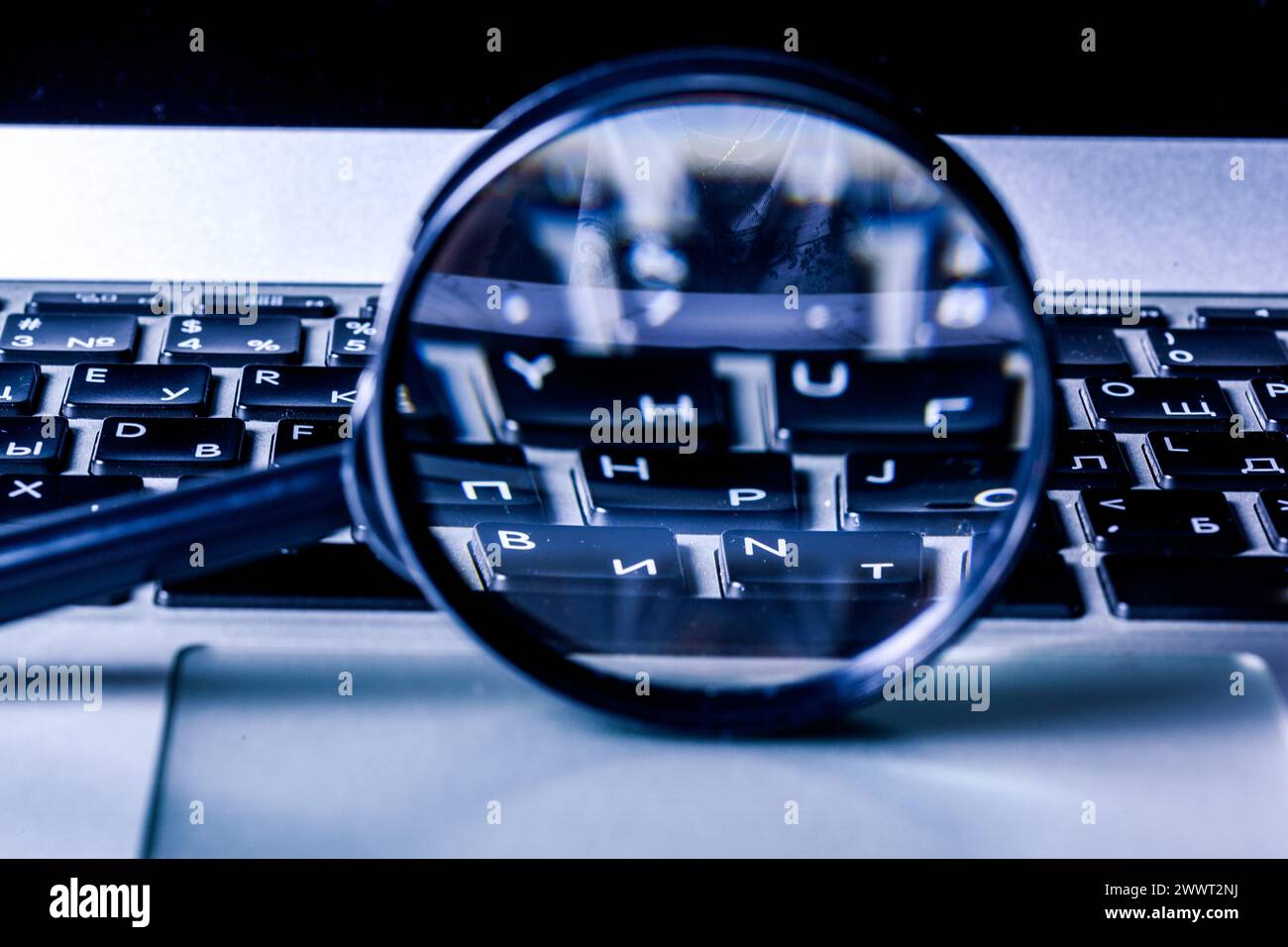 Closeup images of magnifying glass on laptop keyboard Stock Photo - Alamy