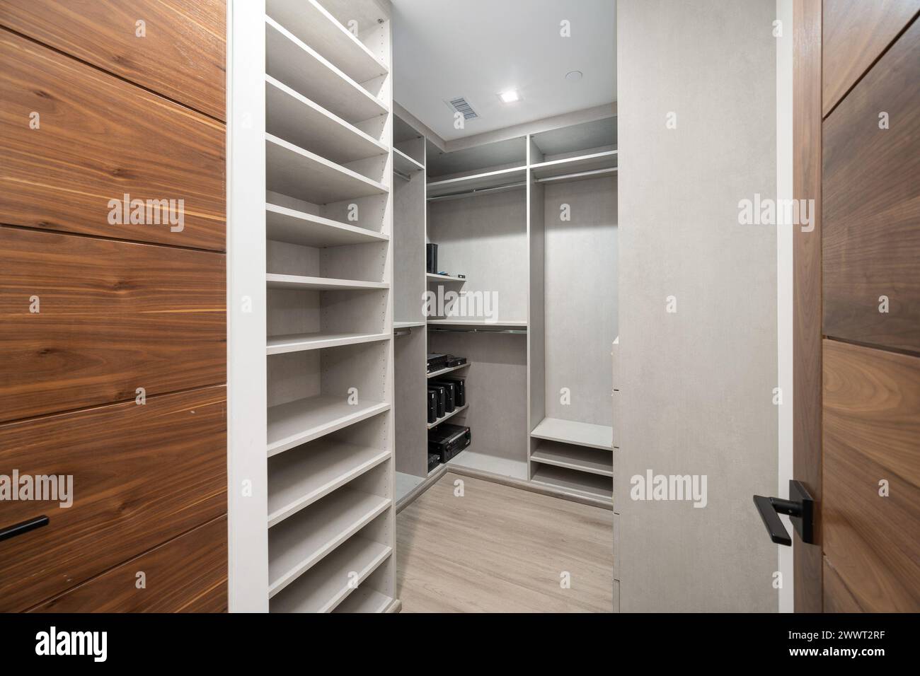 A small walk-in closet with empty shelves or doors Stock Photo - Alamy