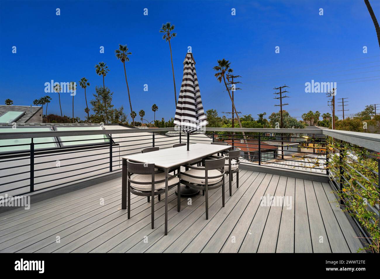 An outdoor patio design with various furniture under a bright blue sky ...