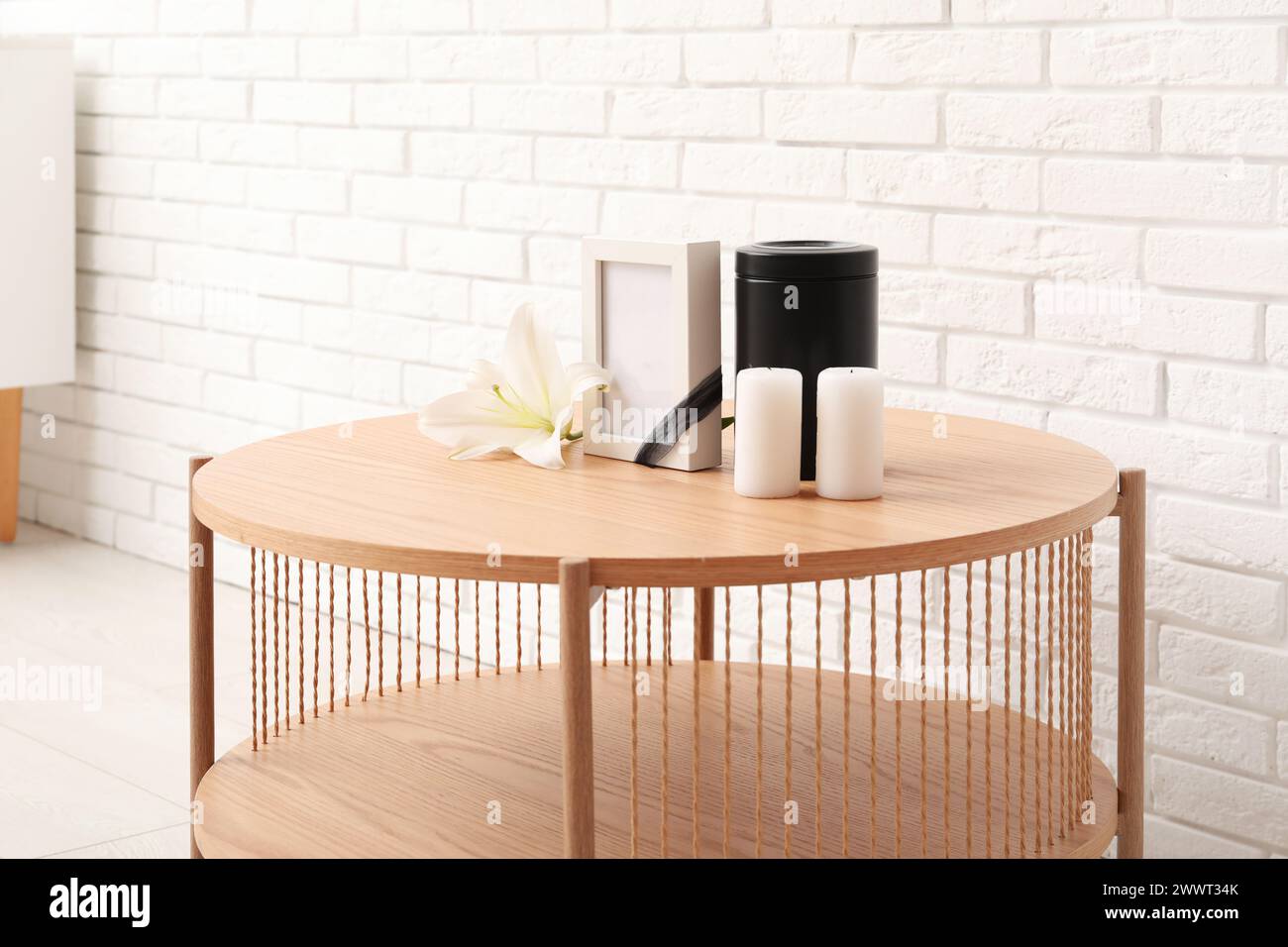 Blank funeral frame, mortuary urn, candles and lily flower on wooden ...