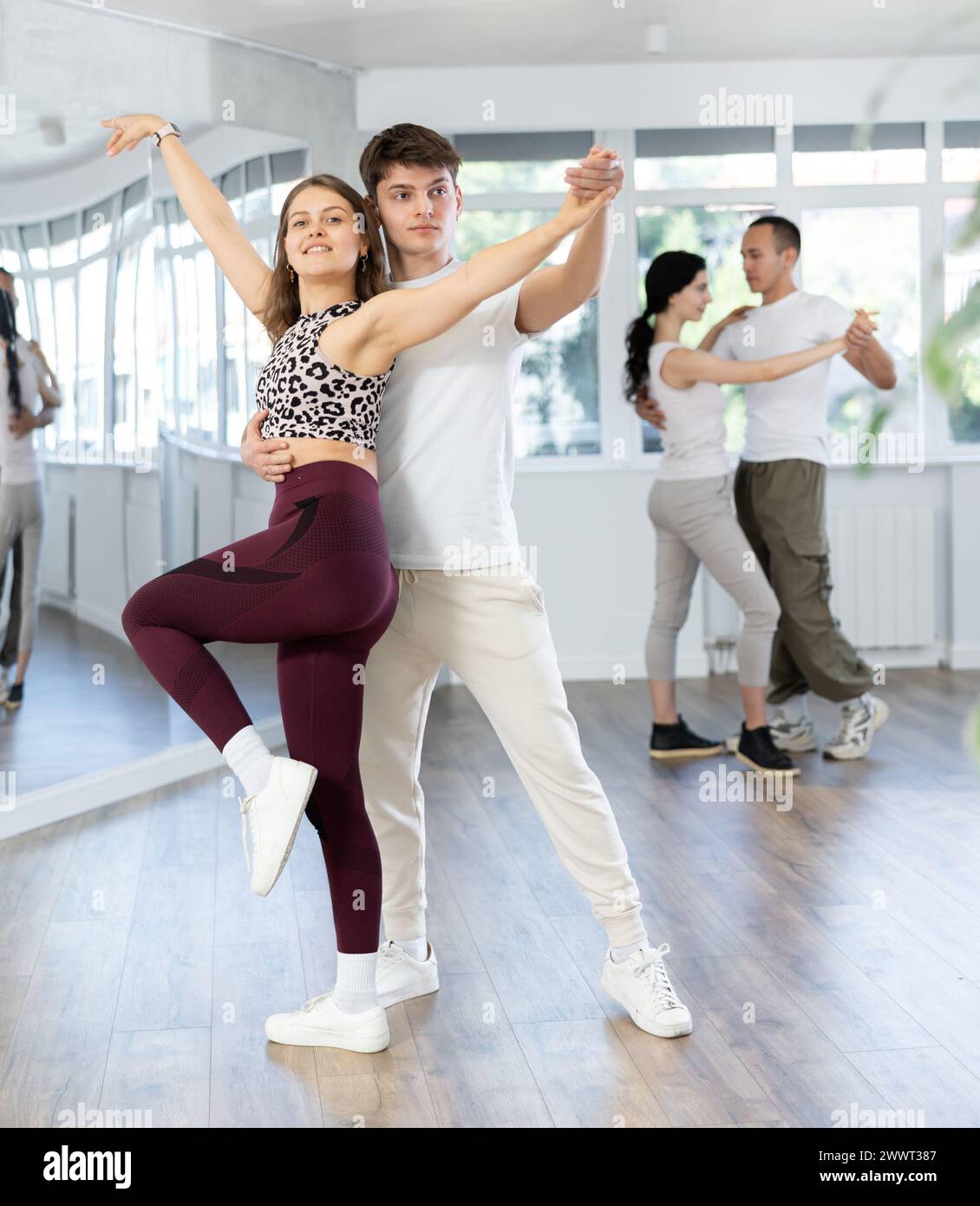 Girl paired up with young man, they train to perform hustle dance ...