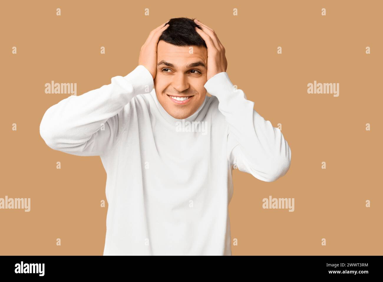 Handsome ashamed young man covering face on brown background Stock ...