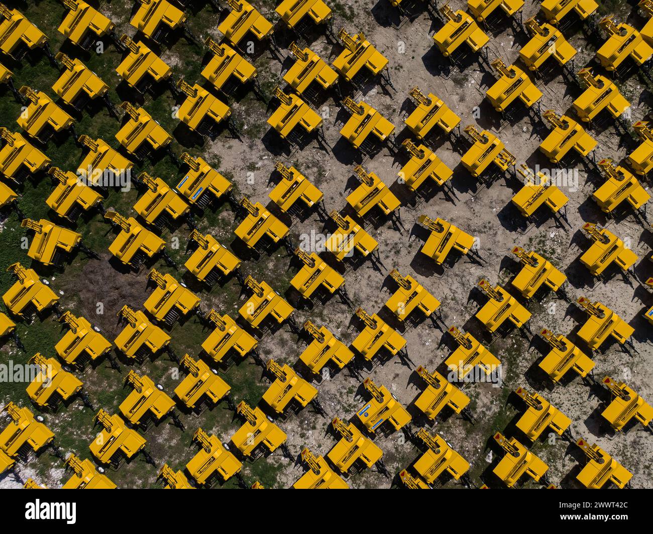 Aerial view of the storage area of yellow coloured balers produced by a ...