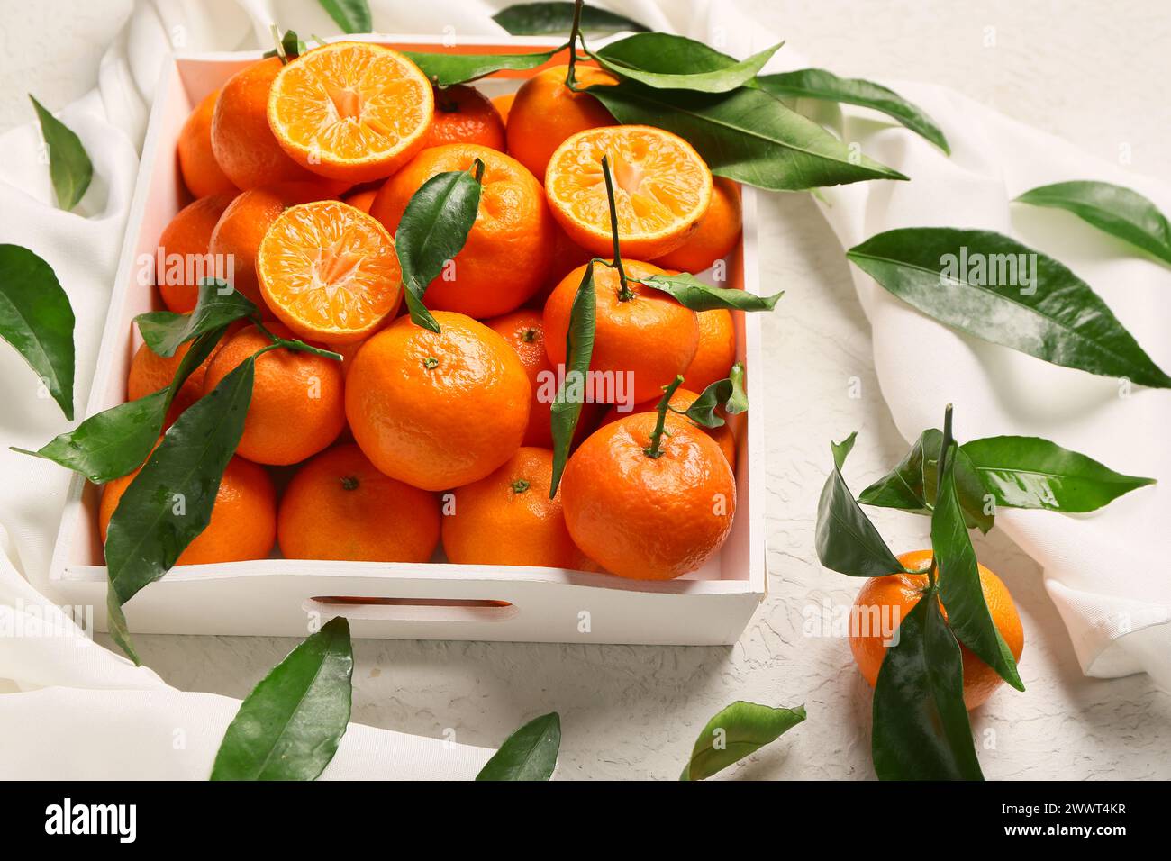 Tray with sweet mandarins and leaves on white background Stock Photo ...