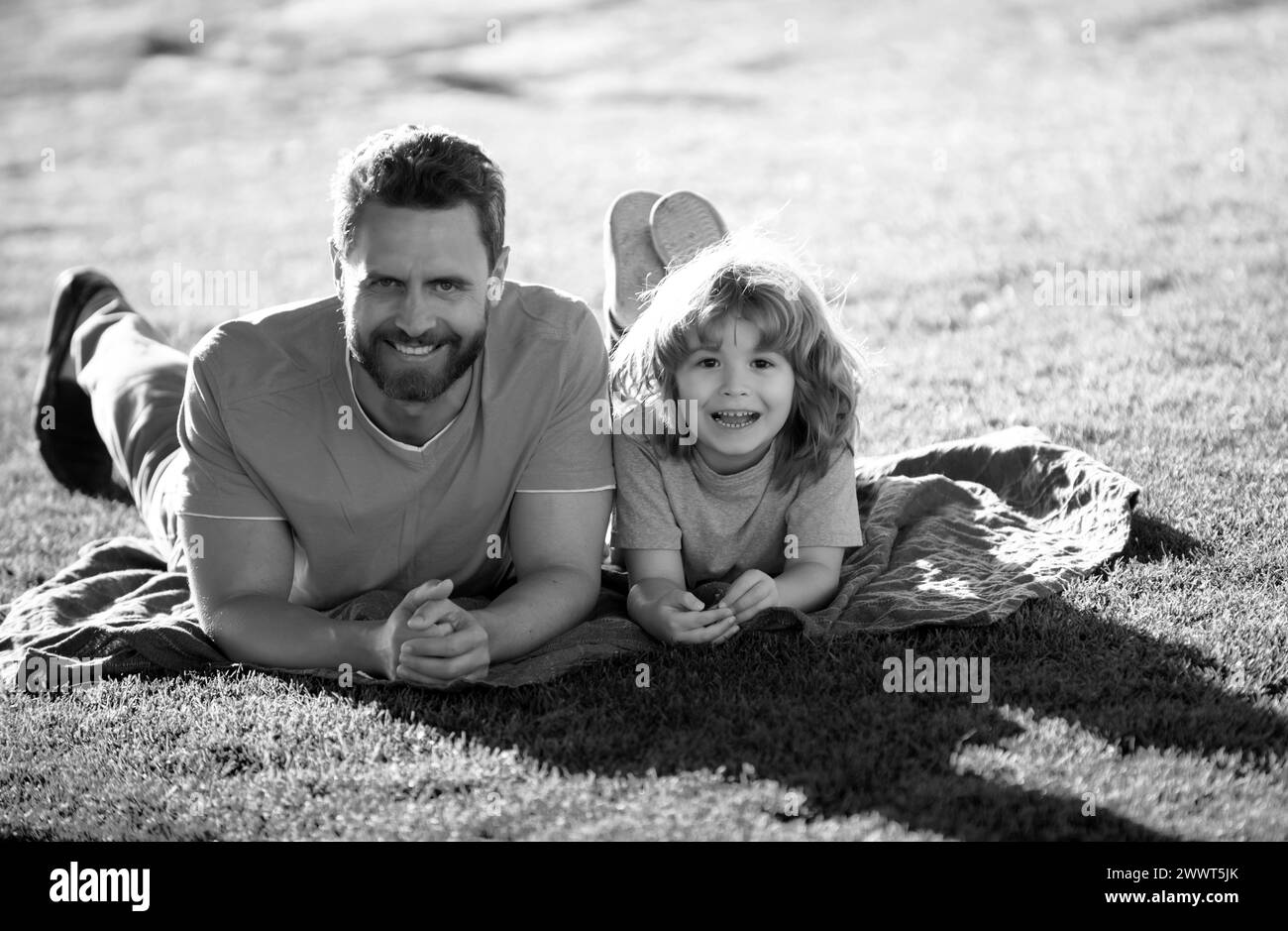 Father and son relaxing on nature in park. Childhood and parenthood ...