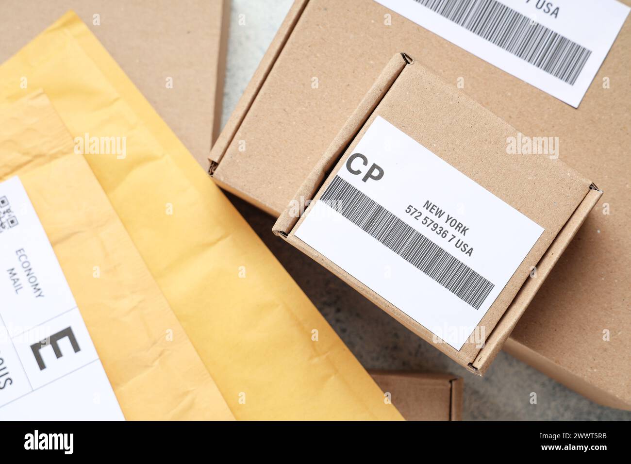 Cardboard packages with labels and barcodes on white table, closeup ...