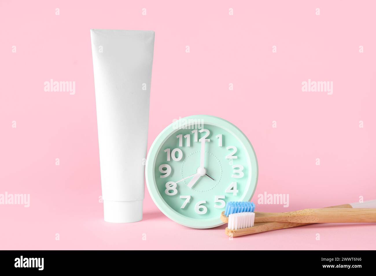 Clock, toothpaste and toothbrush on pink background Stock Photo - Alamy