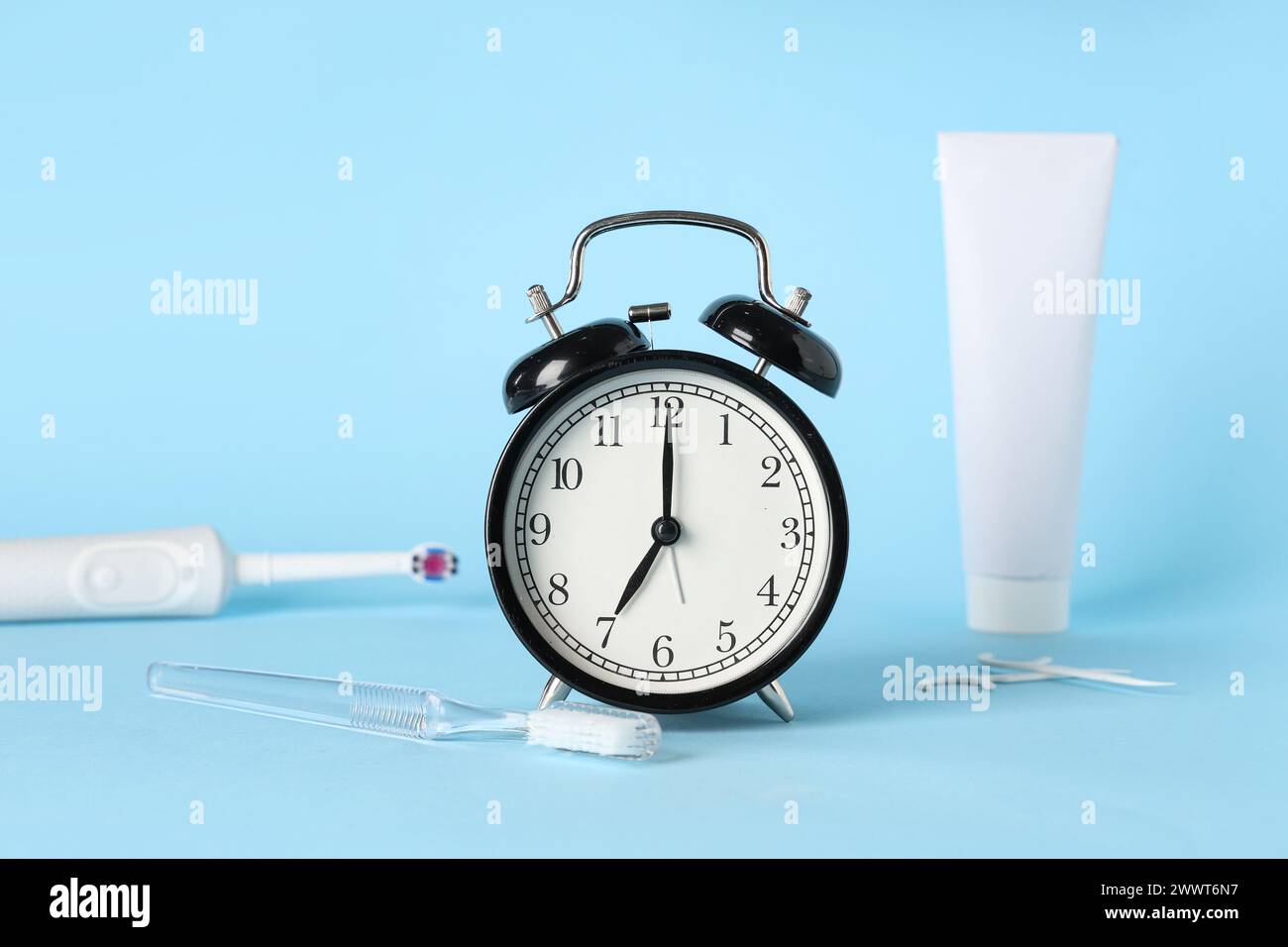 Alarm clock, toothpaste and toothbrushes on blue background Stock Photo ...