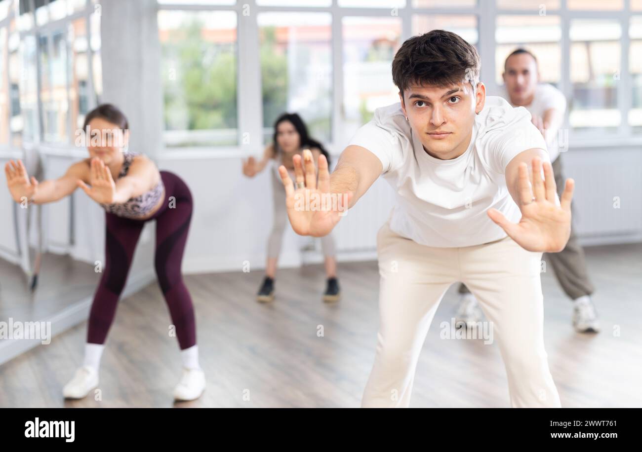 Positive young men and girls dancing modern street dance together ...