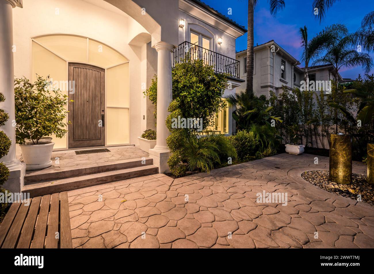 An illuminated stone path and stairs leading to a house entrance at ...