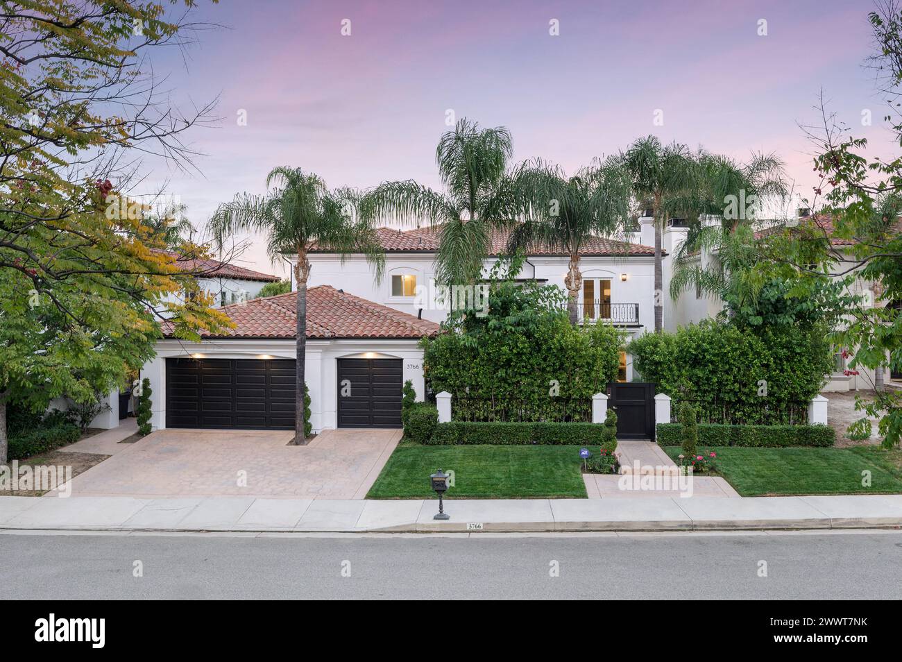 A driveway leading to a house with palm trees at sunset Stock Photo - Alamy