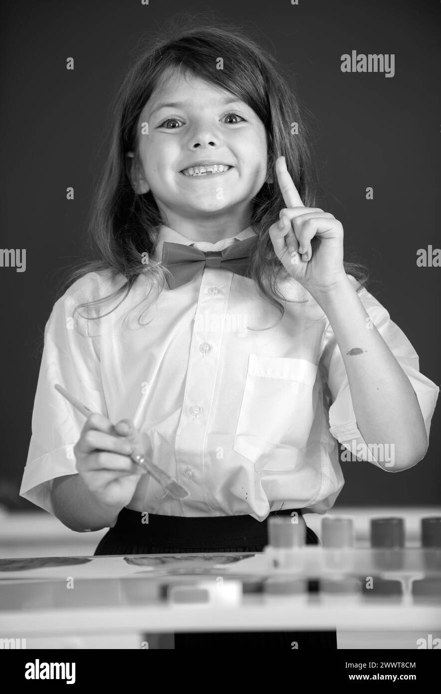 Child girl draws in classroom sitting at a table, having fun on school ...