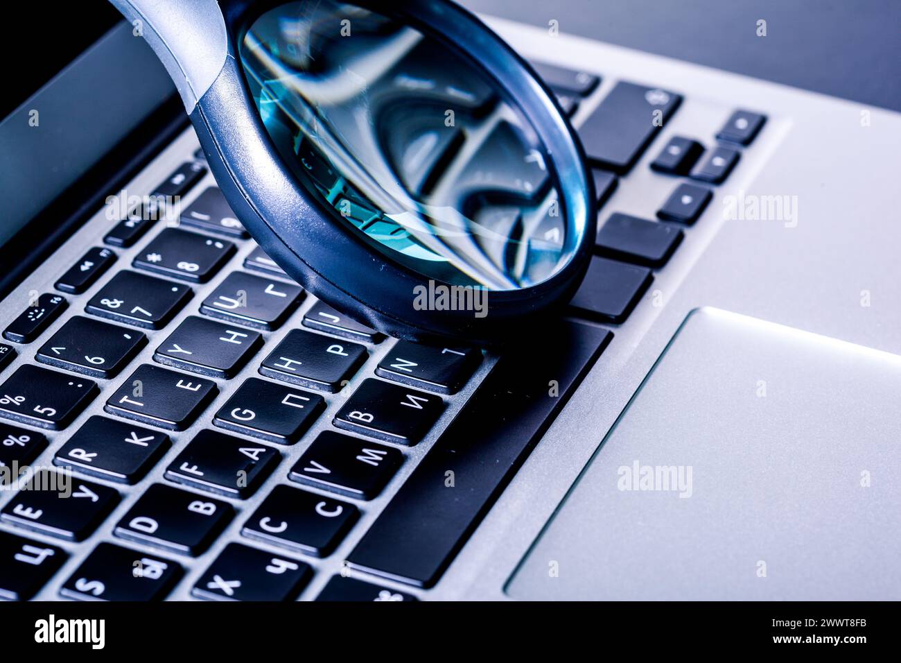 Closeup images of magnifying glass on laptop keyboard Stock Photo - Alamy