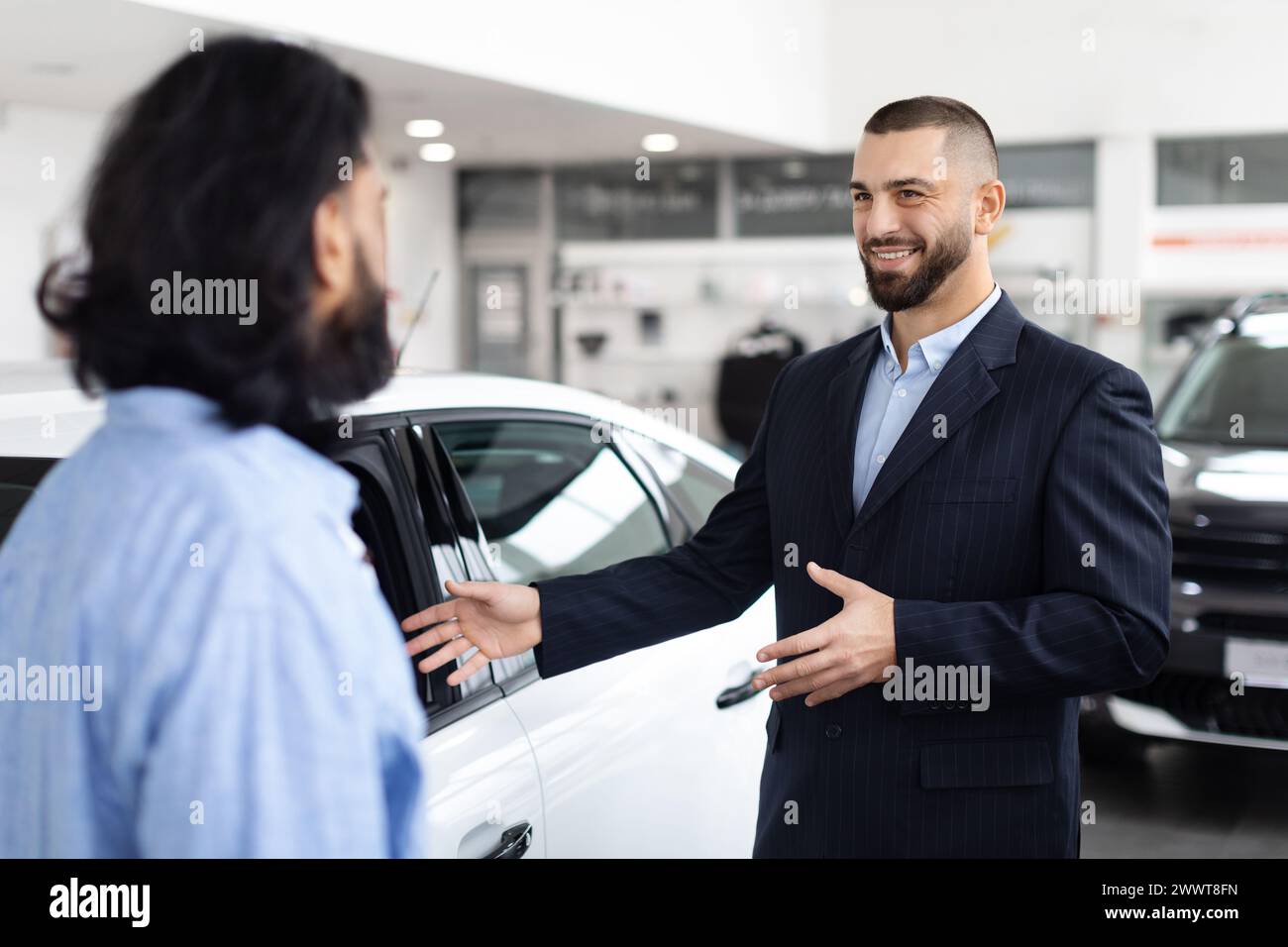 Professional car salesman talking to a client Stock Photo - Alamy
