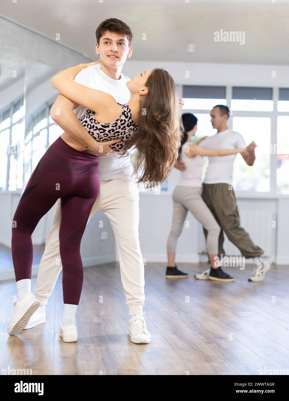 Girl paired up with young man, they train to perform disco fox dance ...