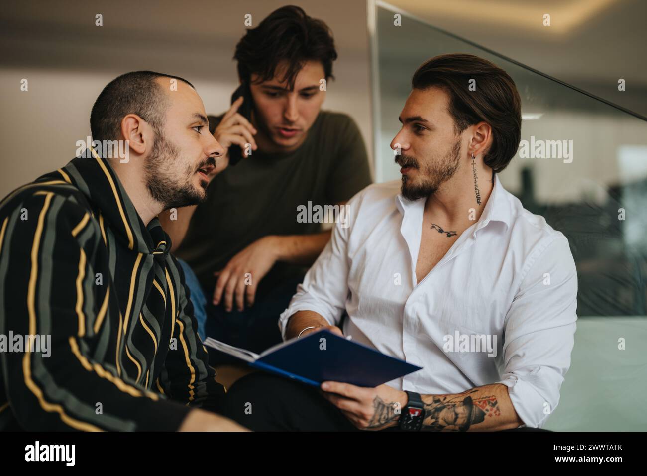 A group of three diverse professionals collaborating with a notepad in ...