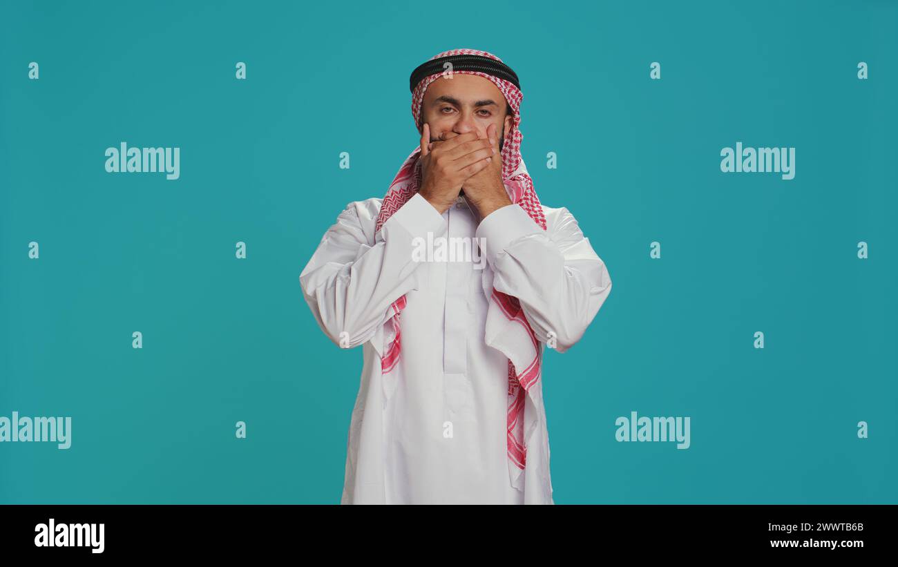 Muslim adult covers eyes, ears and mouth in studio, showcasing three ...