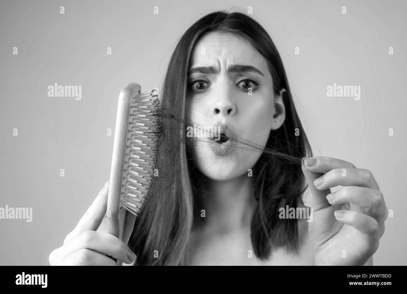 Sad girl looking at damaged hair, the hair loss problem. Isolated, copy ...