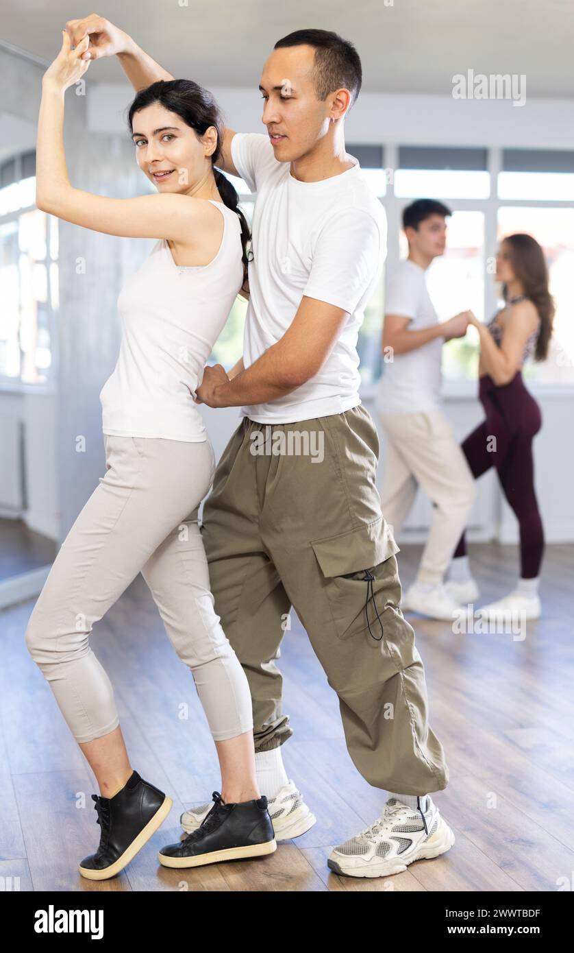 Group of active people dancing social dance movements in studio Stock ...
