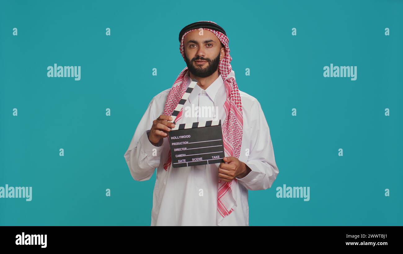 Middle eastern filmmaker holds clapboard used for scene takes on movie ...