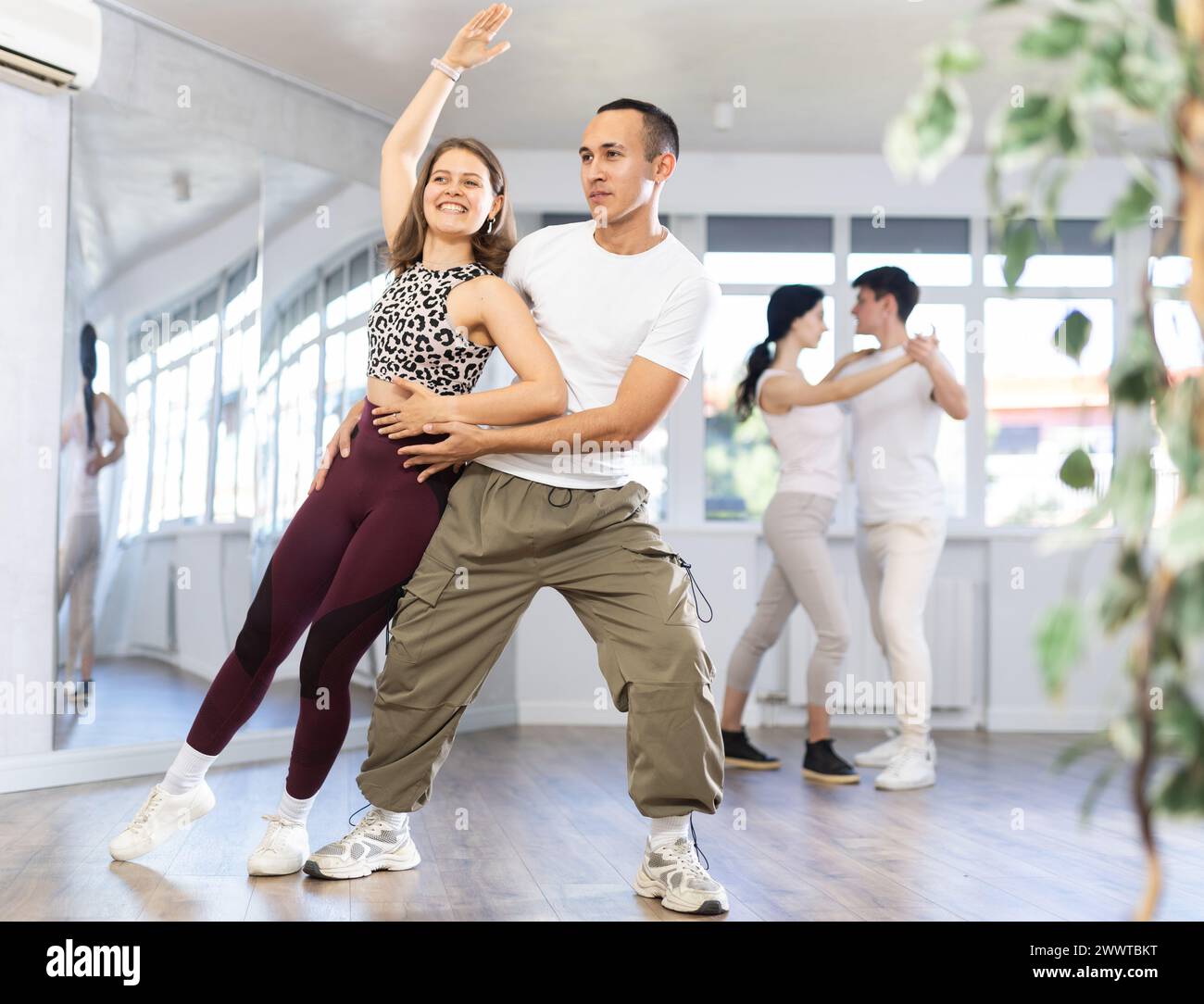 Girl paired up with young man, they train to perform hustle dance ...