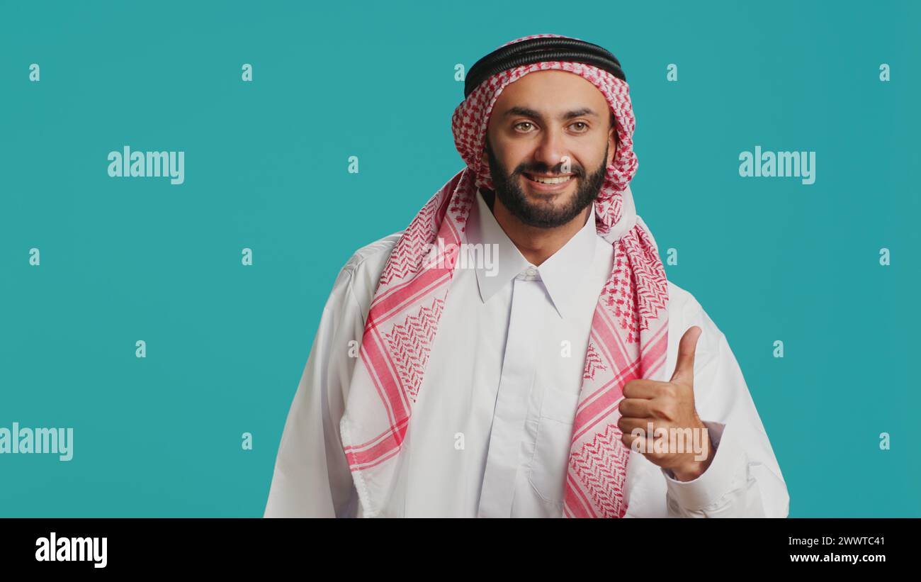 Confident man showing like sign in studio, giving thumbs up and ...