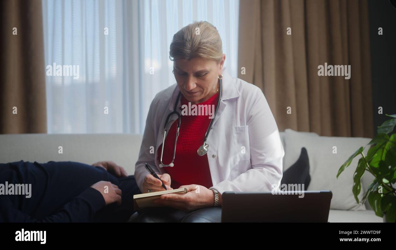 Senior female doctor in white coat with stethoscope examining elderly ...