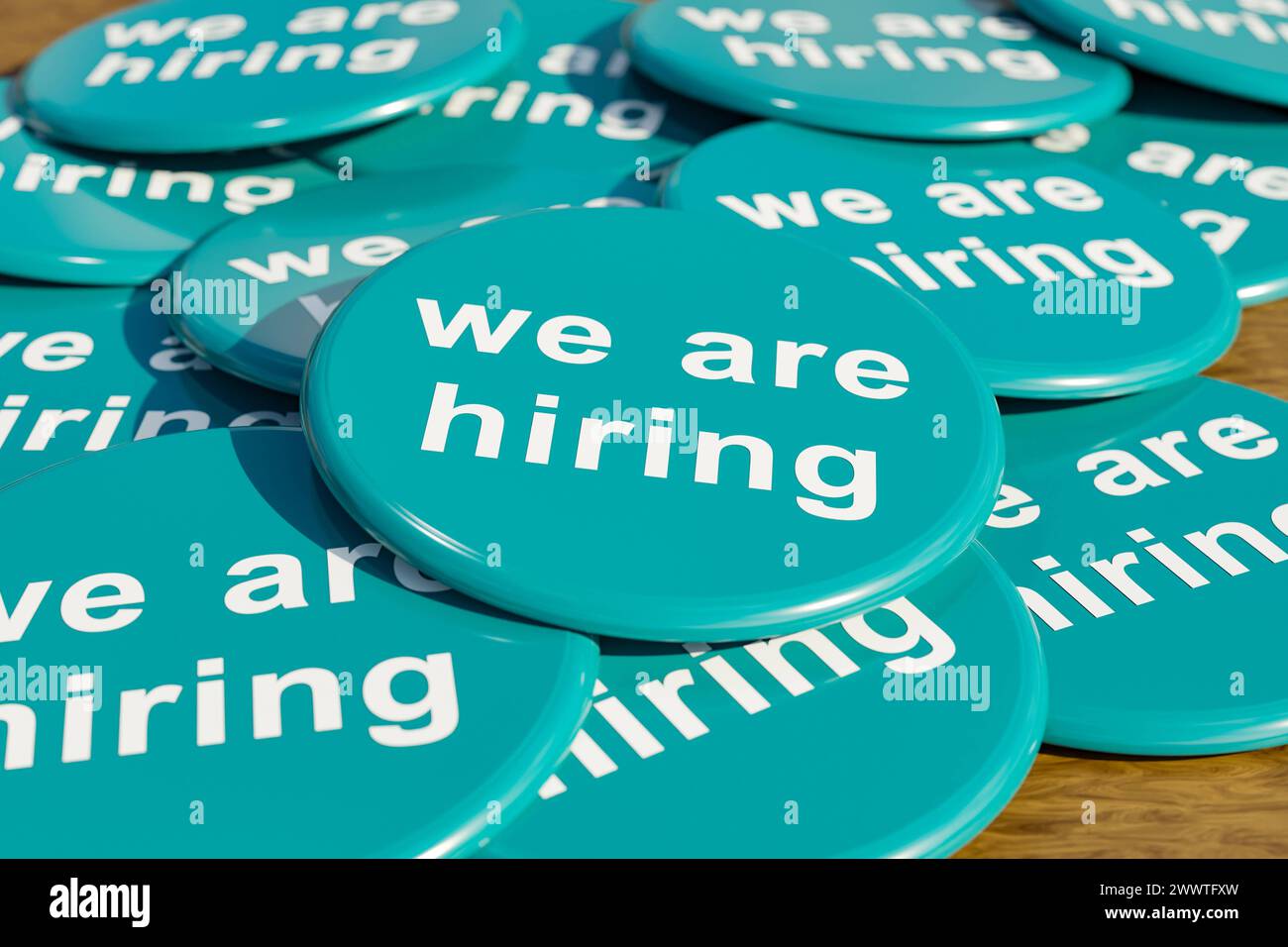 We are hiring. We are hiring. Blue badges laying on the table with the ...